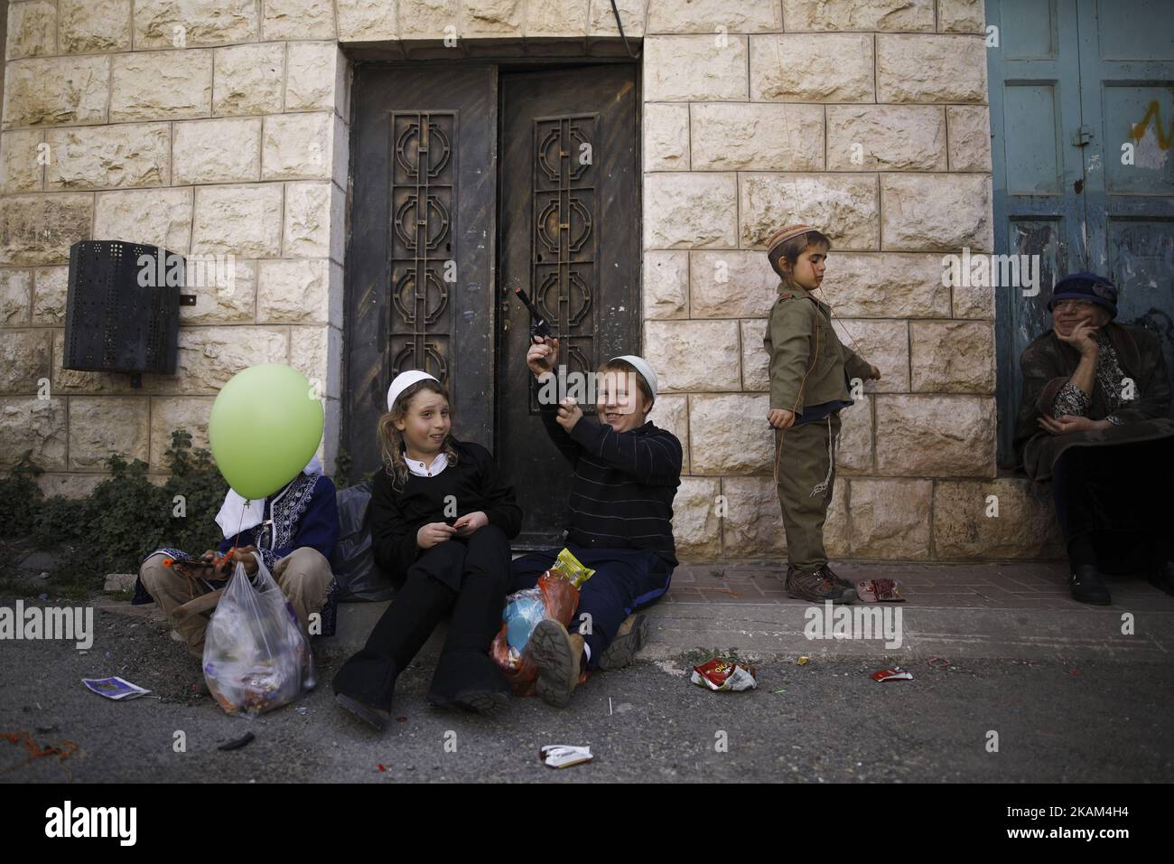 Jewish children play with balloons and toy guns during the annual Purim ...