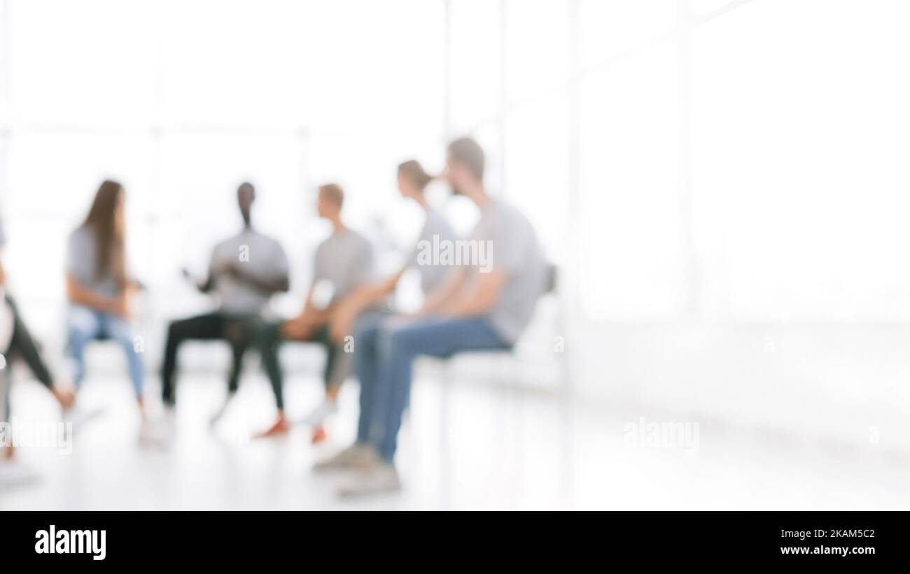 blurry image background image of a group of young people at a meeting ...