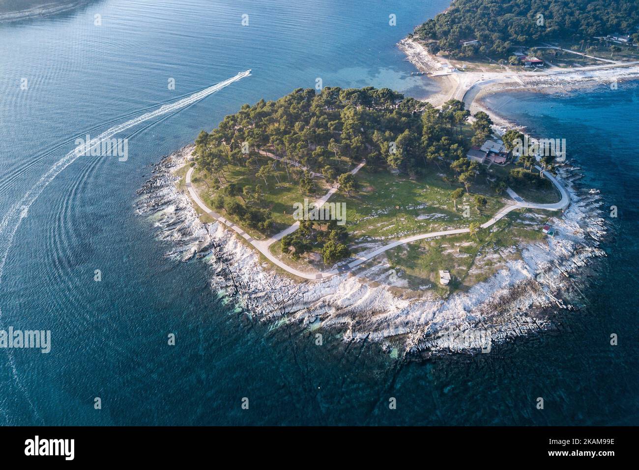An aerial shot of the ocean in Medulin, Croatia with small green island ...