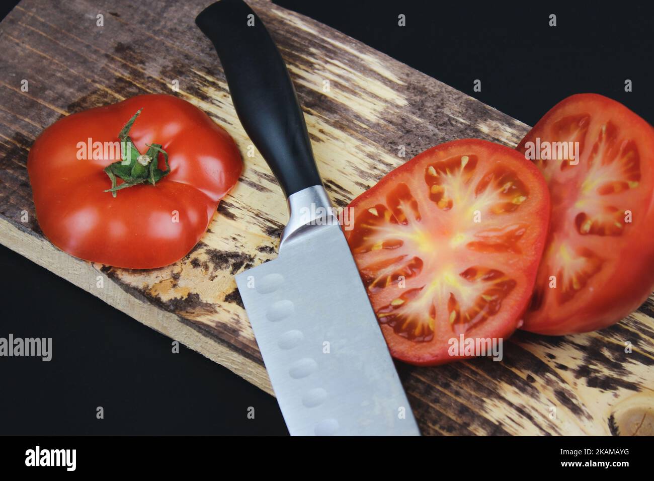 Chopped tomatoes and knife. Circles of red tomatoes on a cutting board ...