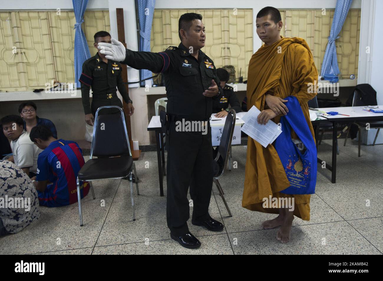 A Buddhist monk wait a physical check-up to a Thai army personnel ...