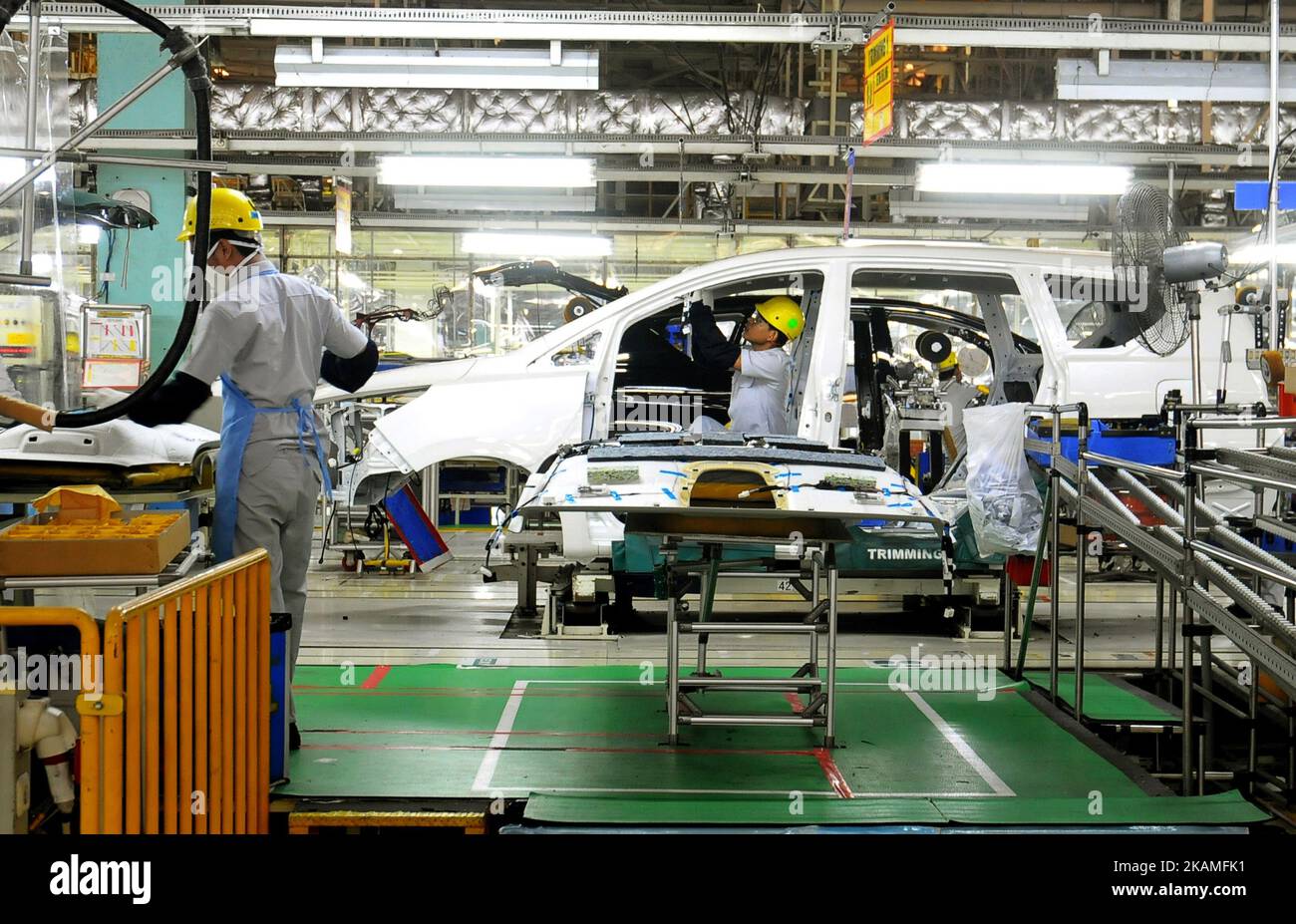 workers installing components to automobile vehicles at Toyota Motor ...