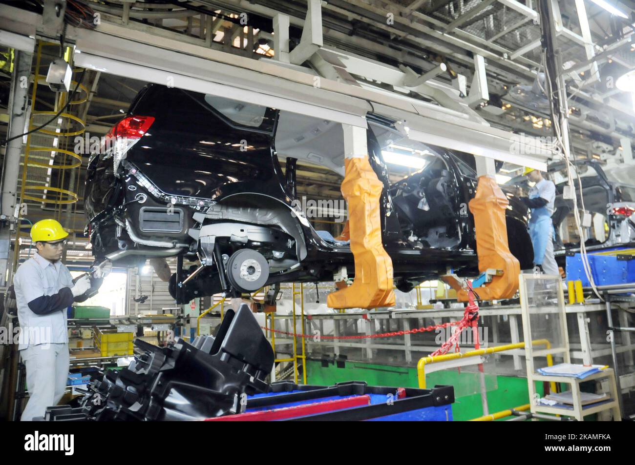 workers installing components to automobile vehicles at Toyota Motor ...