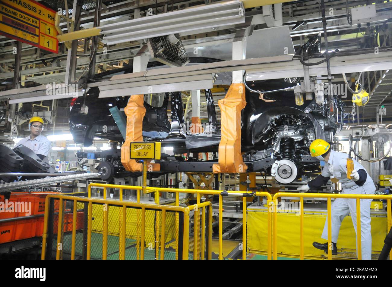workers installing components to automobile vehicles at Toyota Motor ...