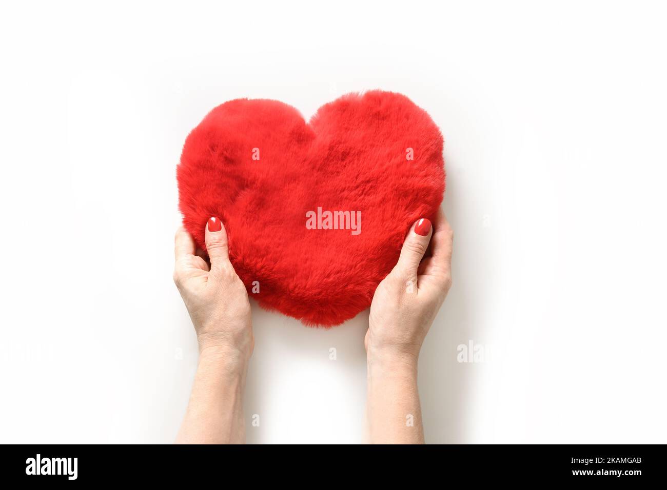 Woman hands holding fur red heart isolated on white background. View ...