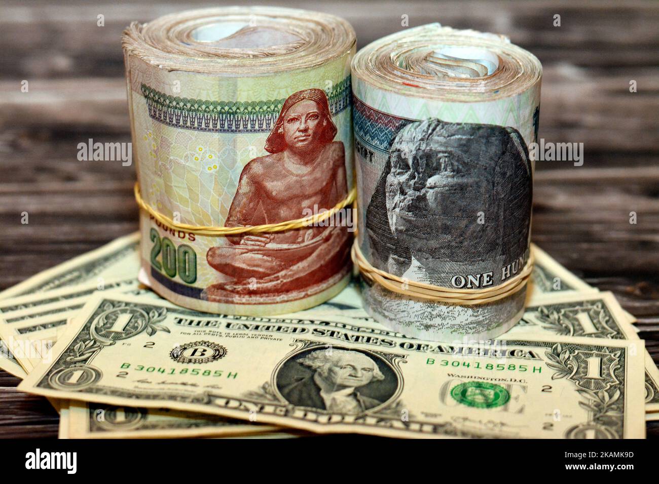 Egyptian money roll of 200 LE and 100 LE and pile of American money ...