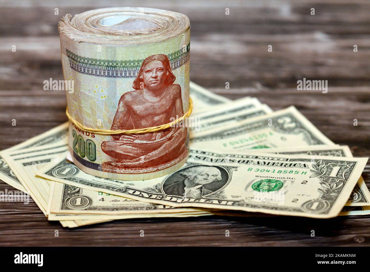 Egyptian money roll of 200 LE and pile of American money isolated on ...