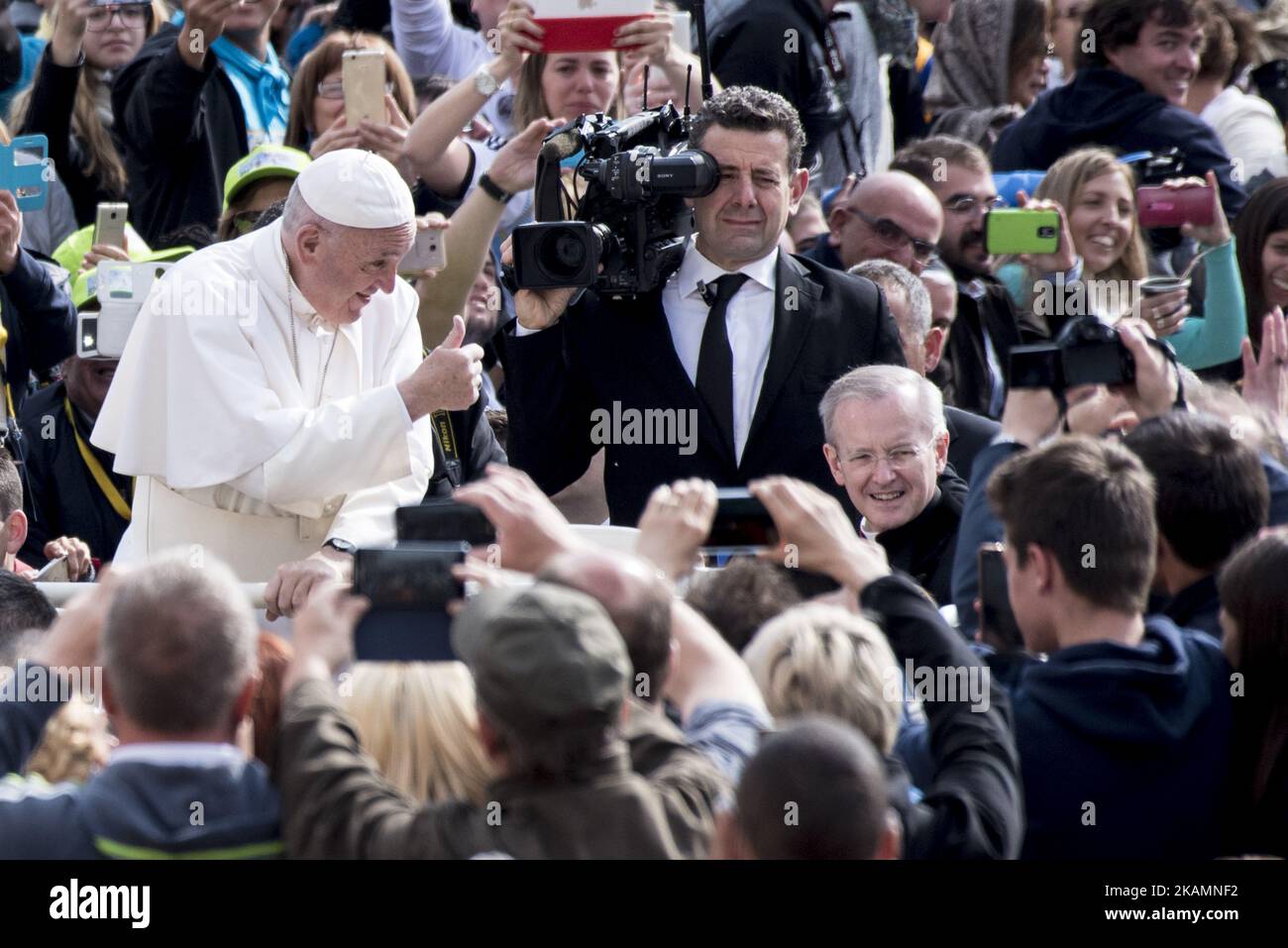 Pope Francis gives the thumbs up sign as he leaves St. Peter's Square ...