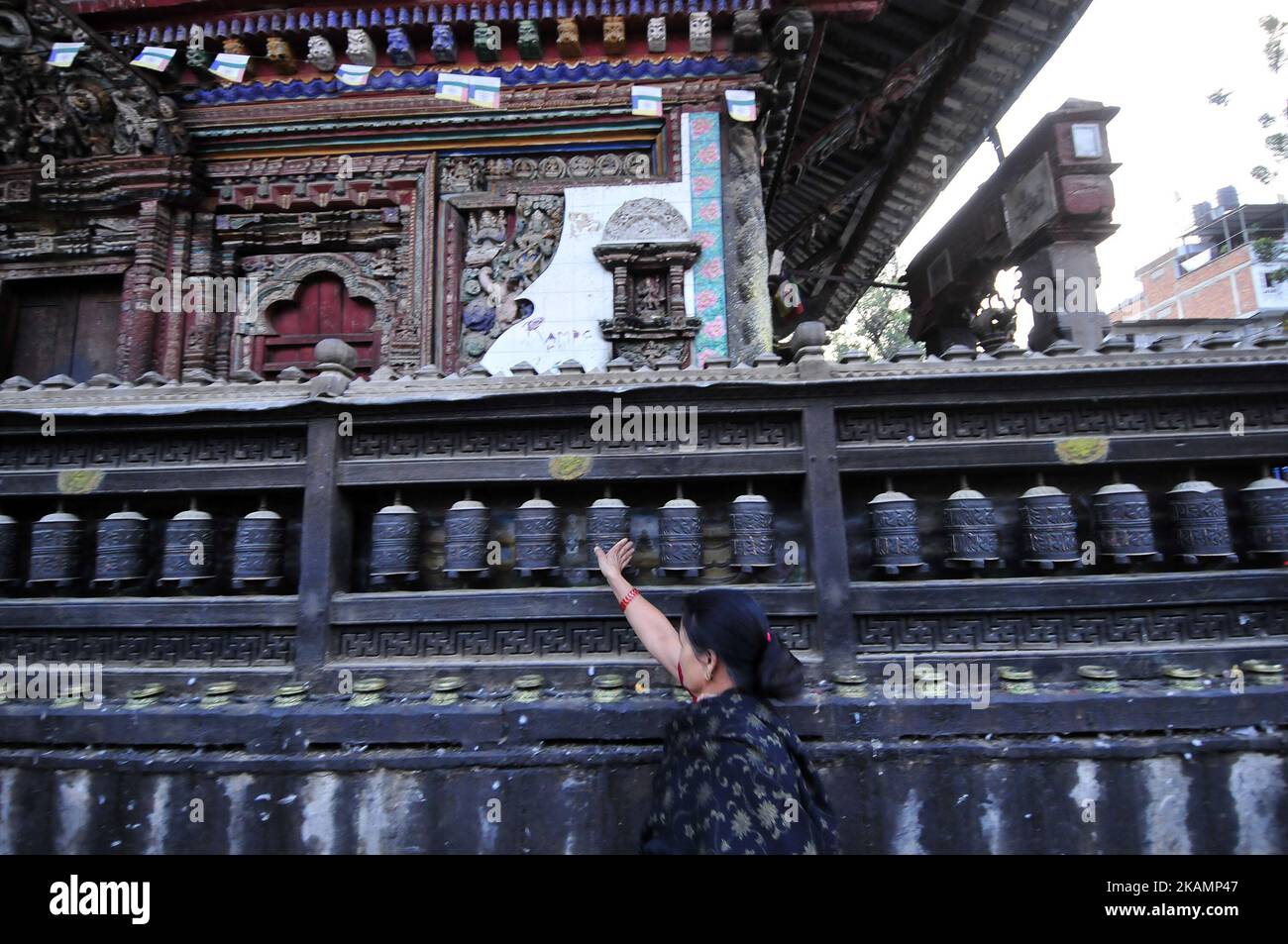 A devotee rolling prayer wheel around on first day of festival ...
