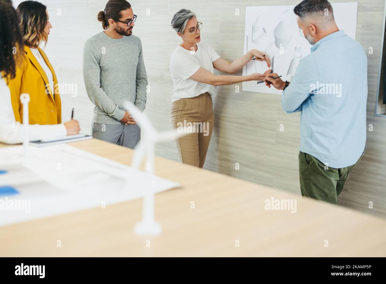 Mature design professional explaining some drawings during a meeting ...