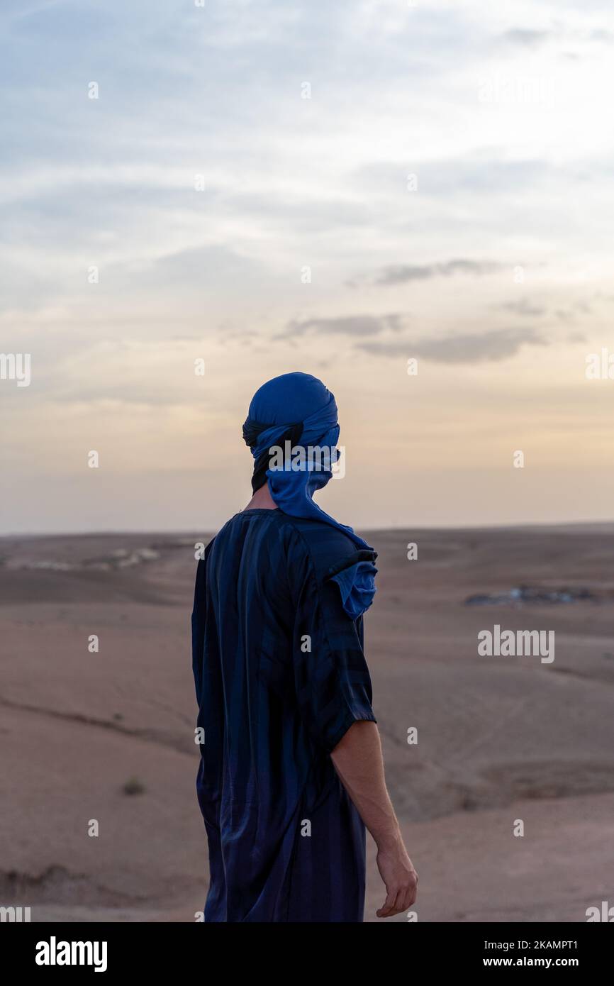 A medium shot of a back-facing male person, standing and wearing ...