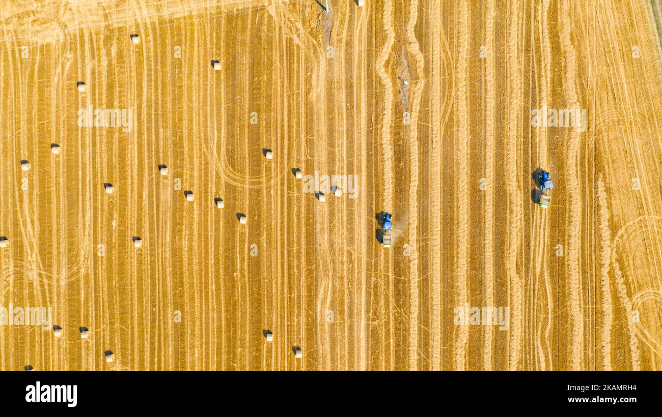 Above top view on two tractors as they pulling round baler, machines ...