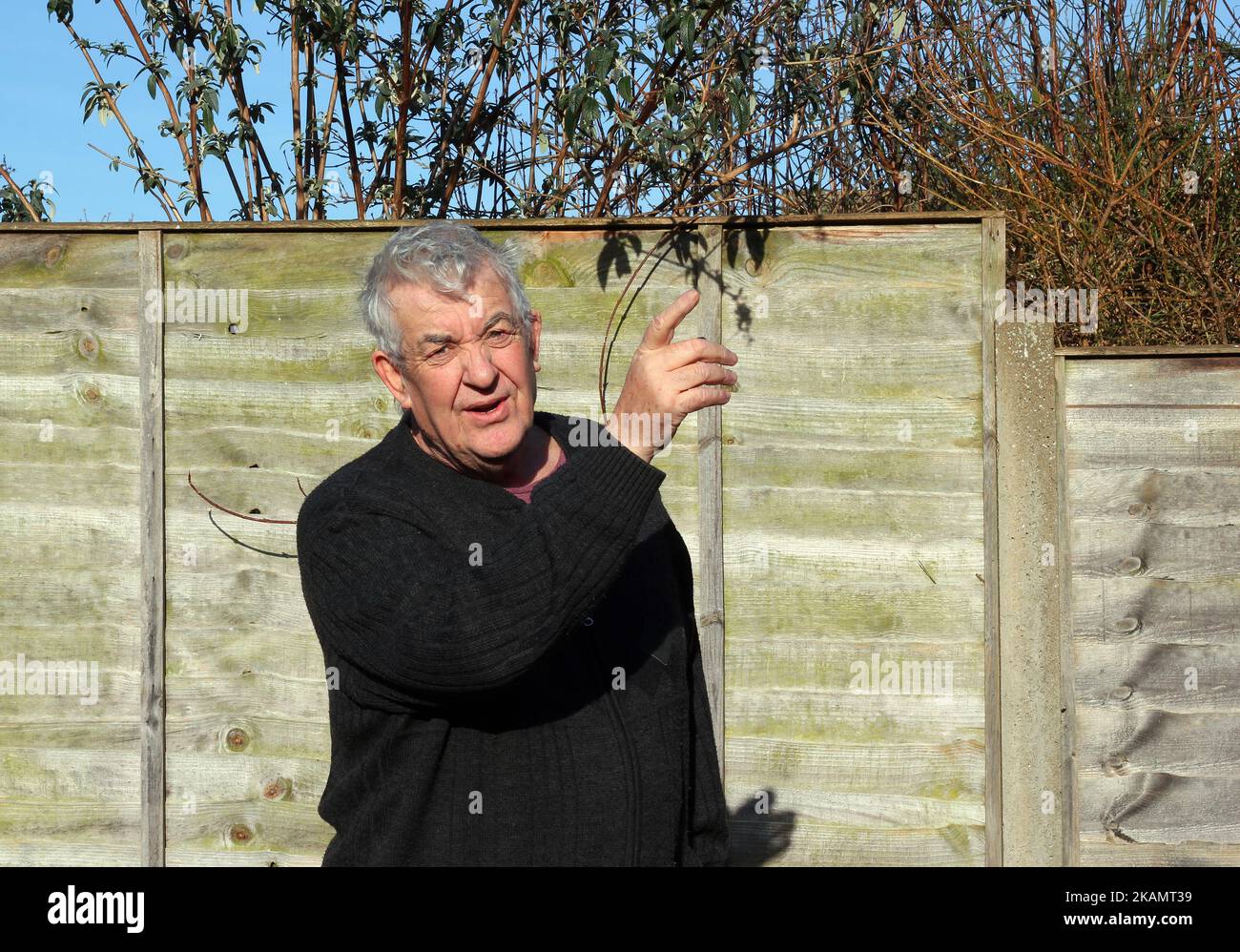 Senior man looking towards the camera and pointing direction either ...