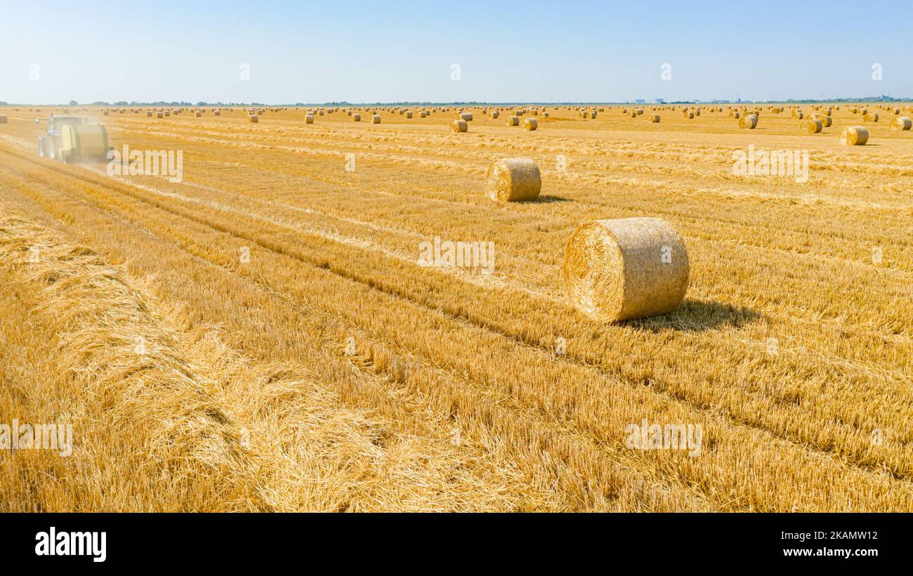 Above view on tractor as pulling round baler, machine that rolls up the ...