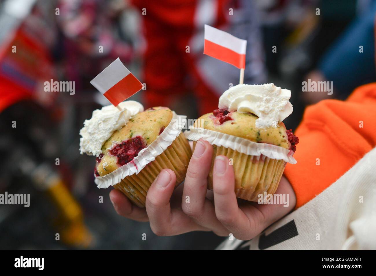 A person carrying two small cakes with Polish flags on Poland's Flag ...