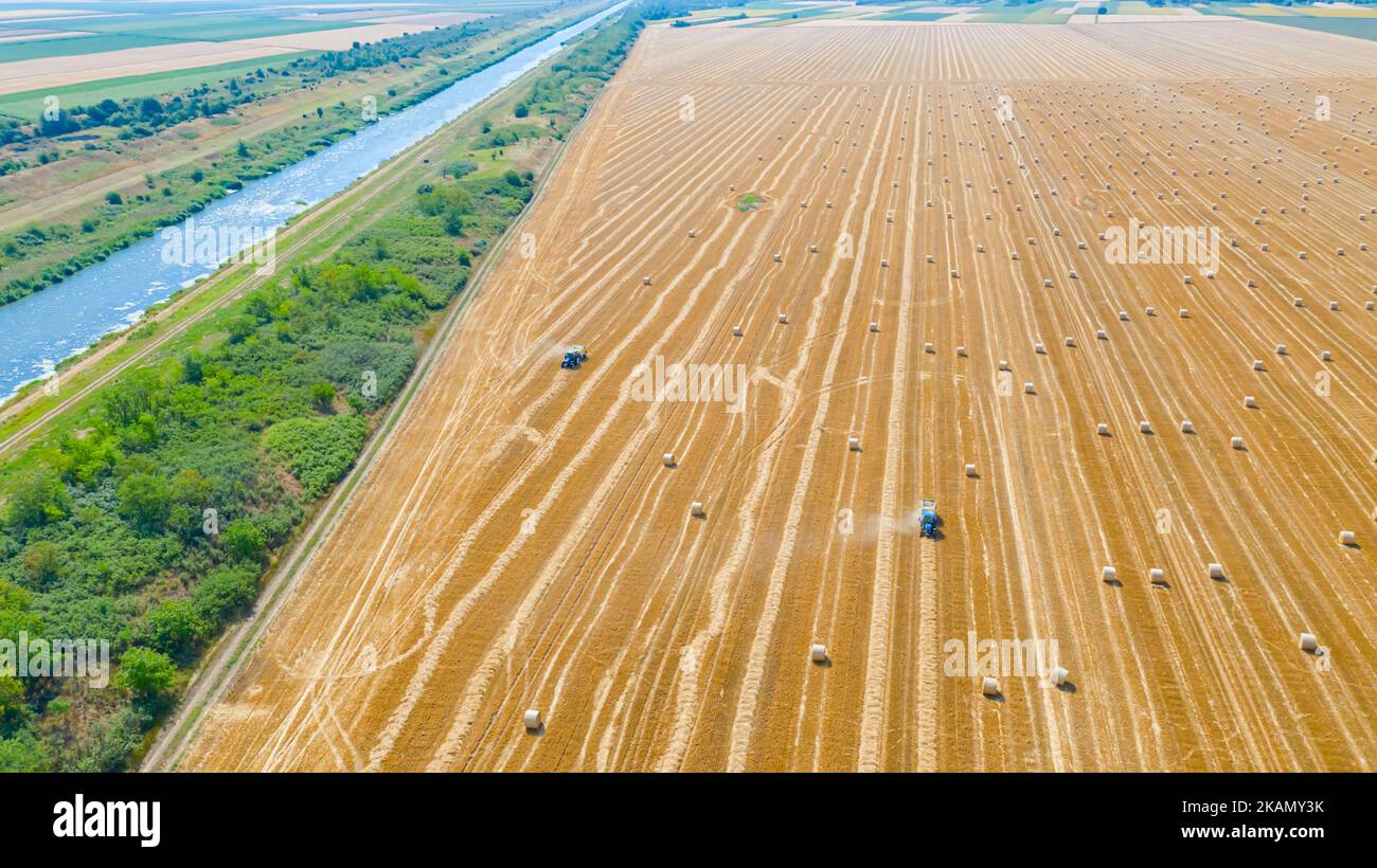Above view on tractor as pulling round baler, machine that rolls up the ...