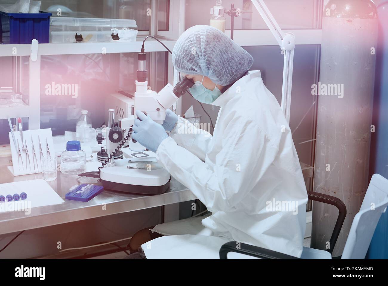 Medic or scientist looking through a microscope in a scientific medical ...