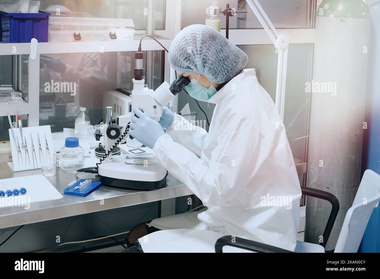 Medic or scientist looking through a microscope in a scientific medical ...