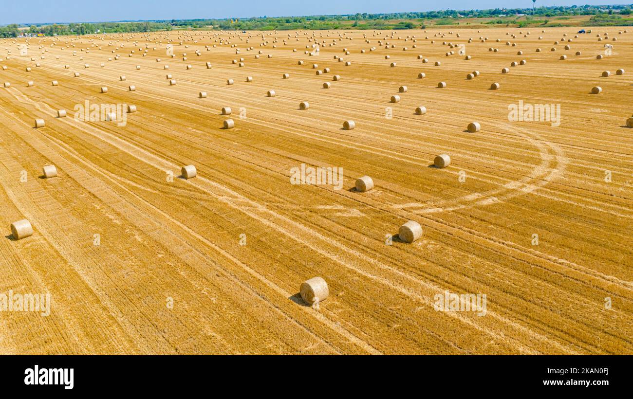 Above view on tractor as pulling round baler, machine that rolls up the ...
