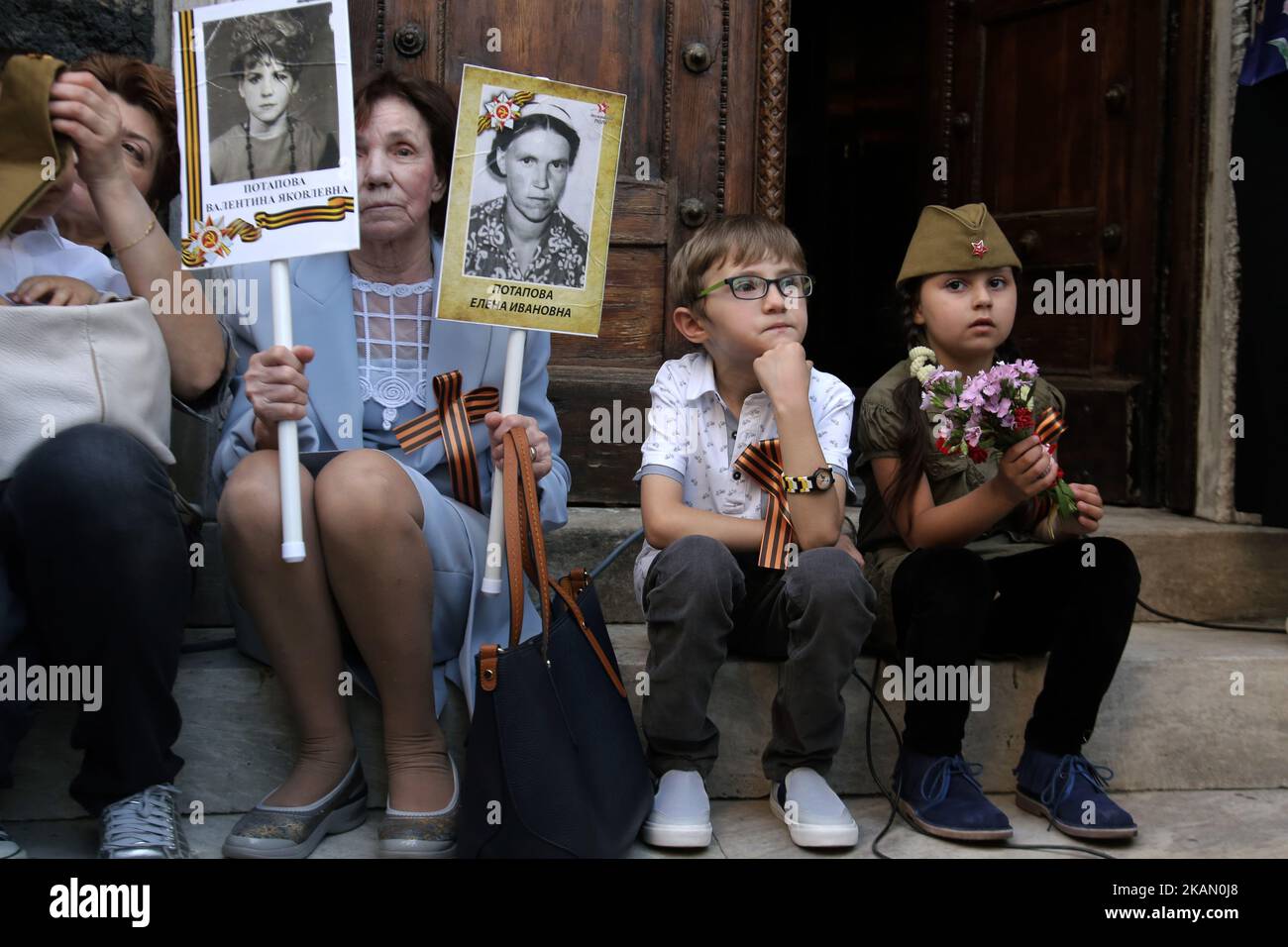 Members of the Russian community hold pictures of relatives taking part ...