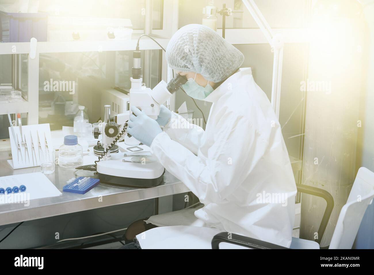 Medic or scientist looking through a microscope in a scientific medical ...