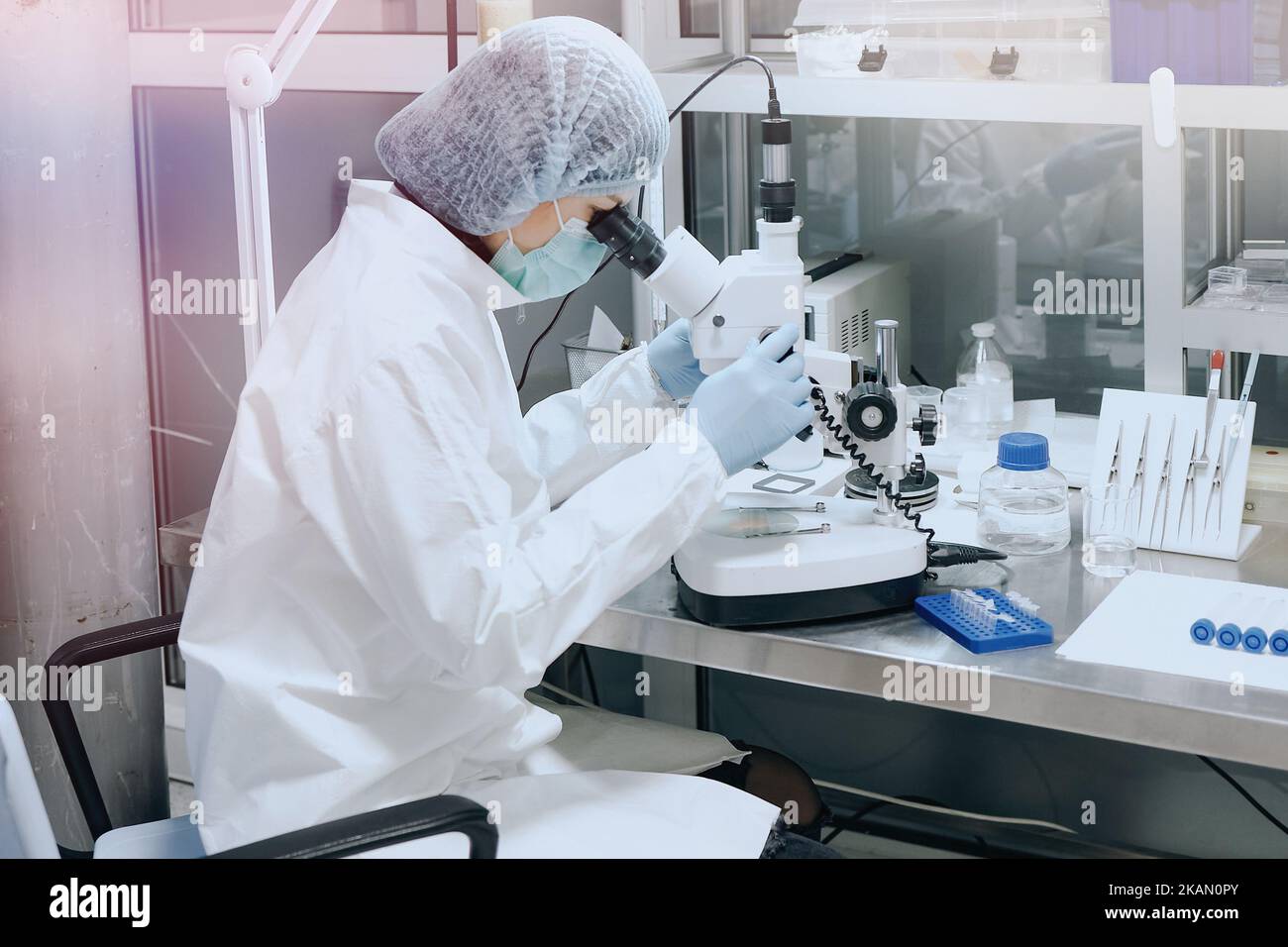 Medic or scientist looking through a microscope in a scientific medical ...