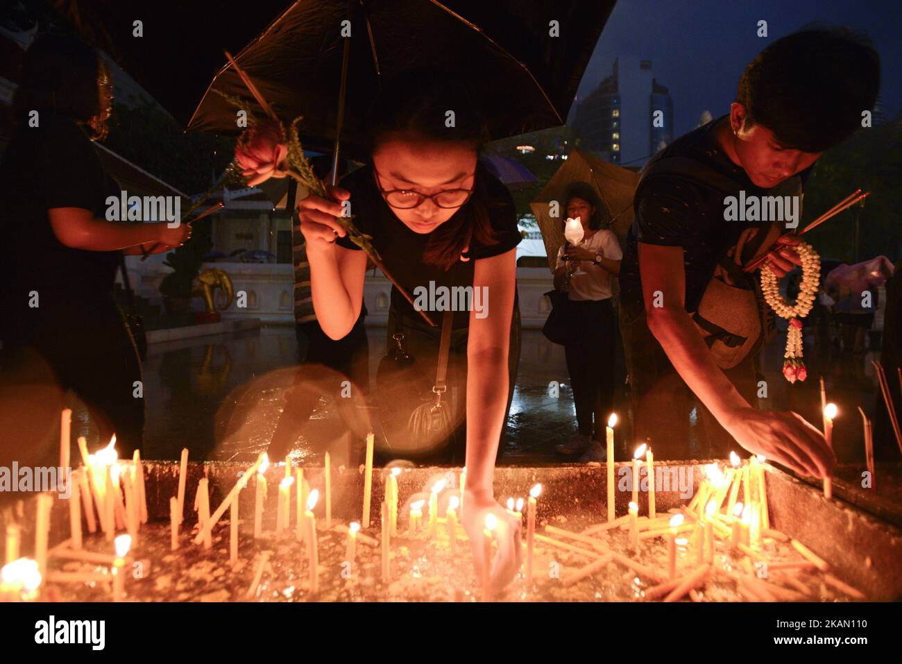 A girl lights a candle to celebrate during a ceremony marking Visakha ...