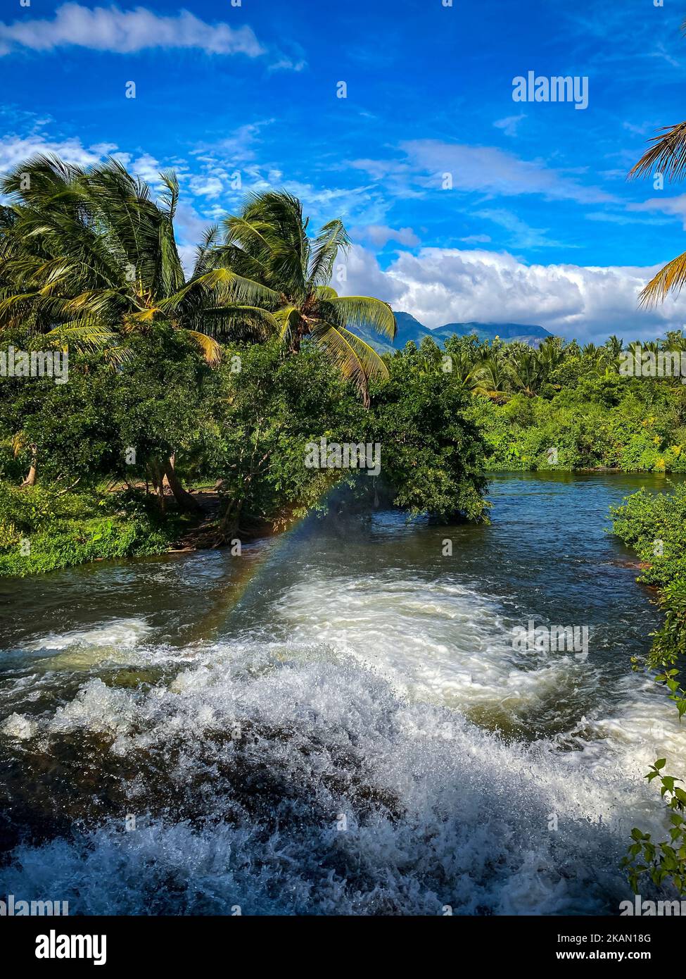 A vertical shot of the rainbow in the river side landscape Stock Photo ...