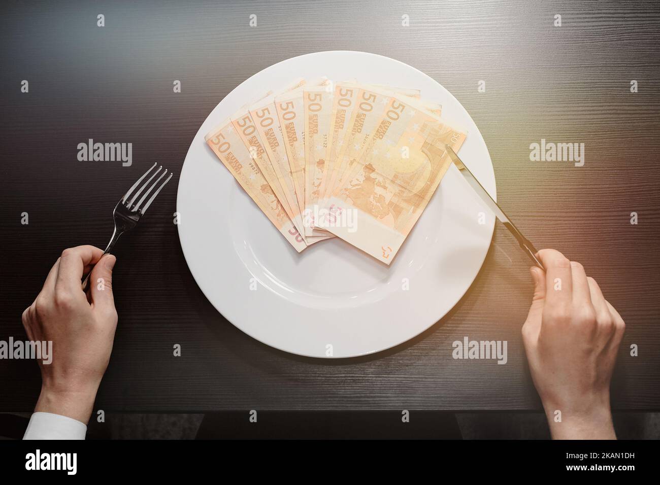 Money on a plate with a fork and knife. Euro banknotes. Wealth and the ...