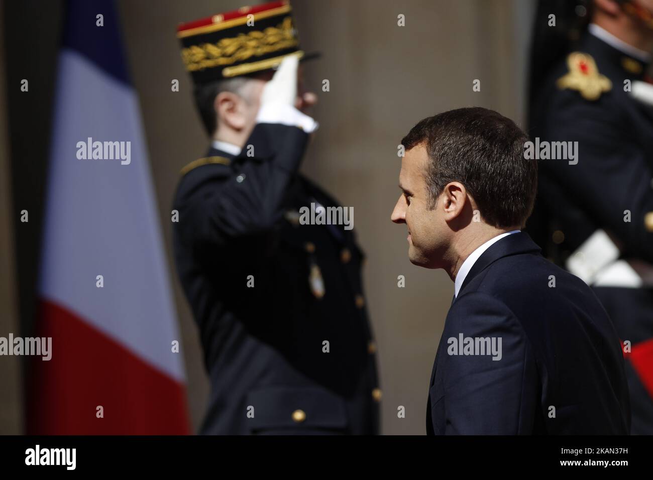New French President Emmanuel Macron walks back along the red carpet ...