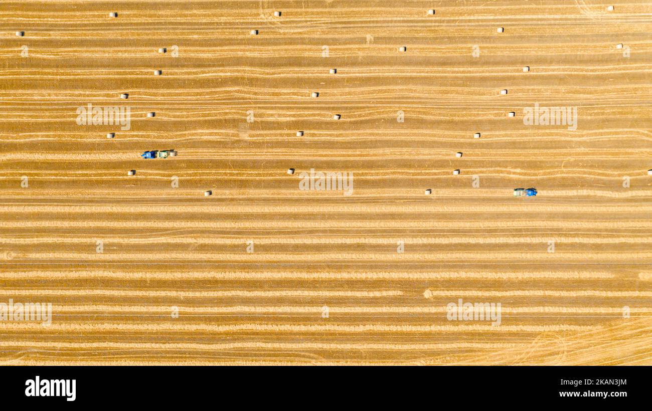 Above top view on two tractors as they pulling round baler, machines ...