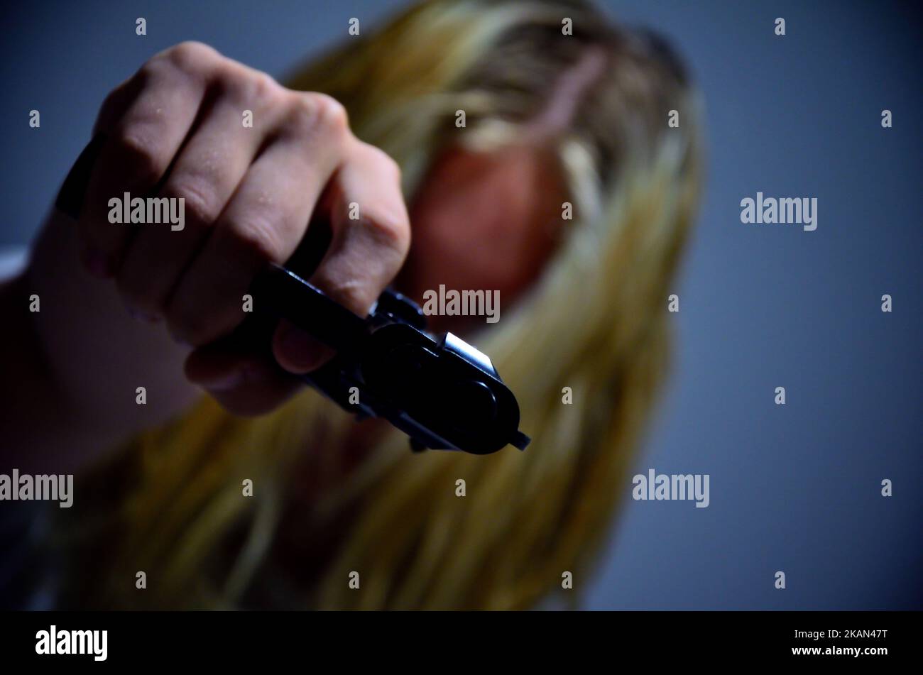 A female comitting suicide with a gun pointing on her forehead Stock ...