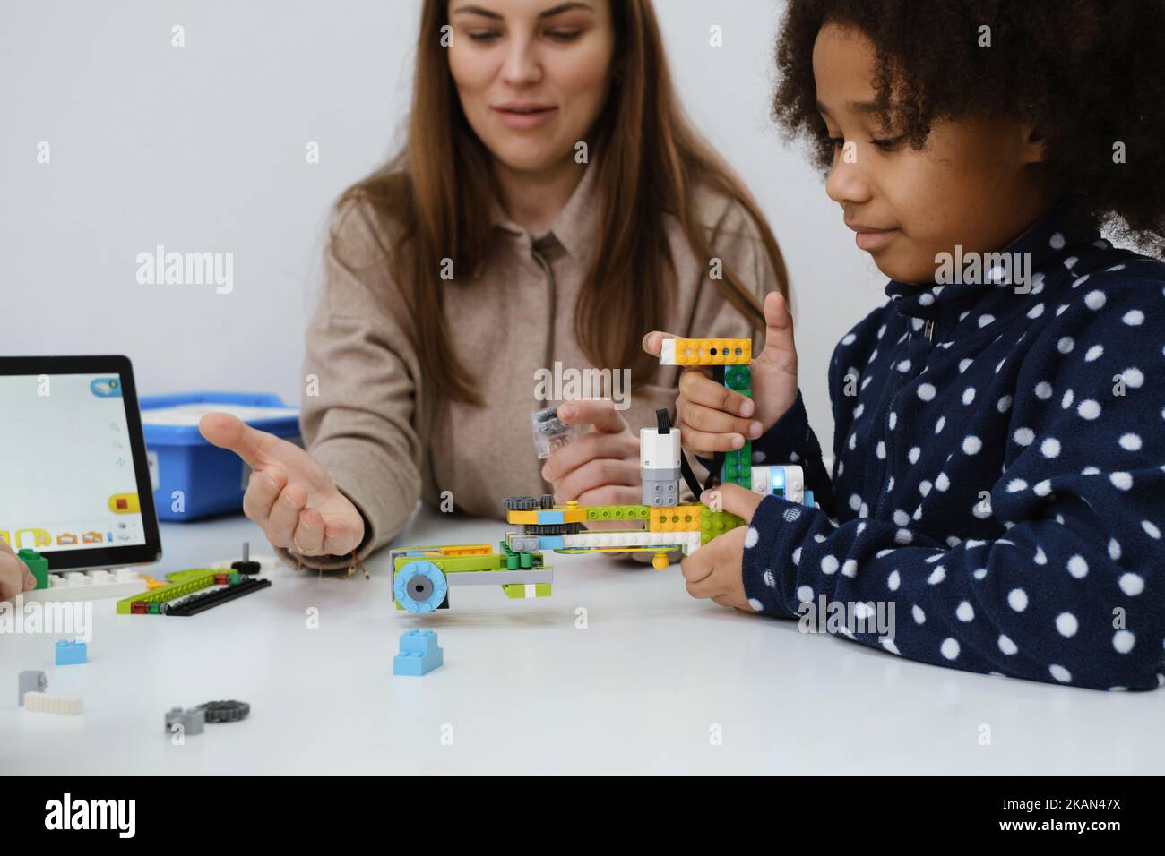 Multiethnic kids at STEM lesson constructing robot in classroom with ... Multiethnic kids at STEM lesson constructing robot in classroom with ...