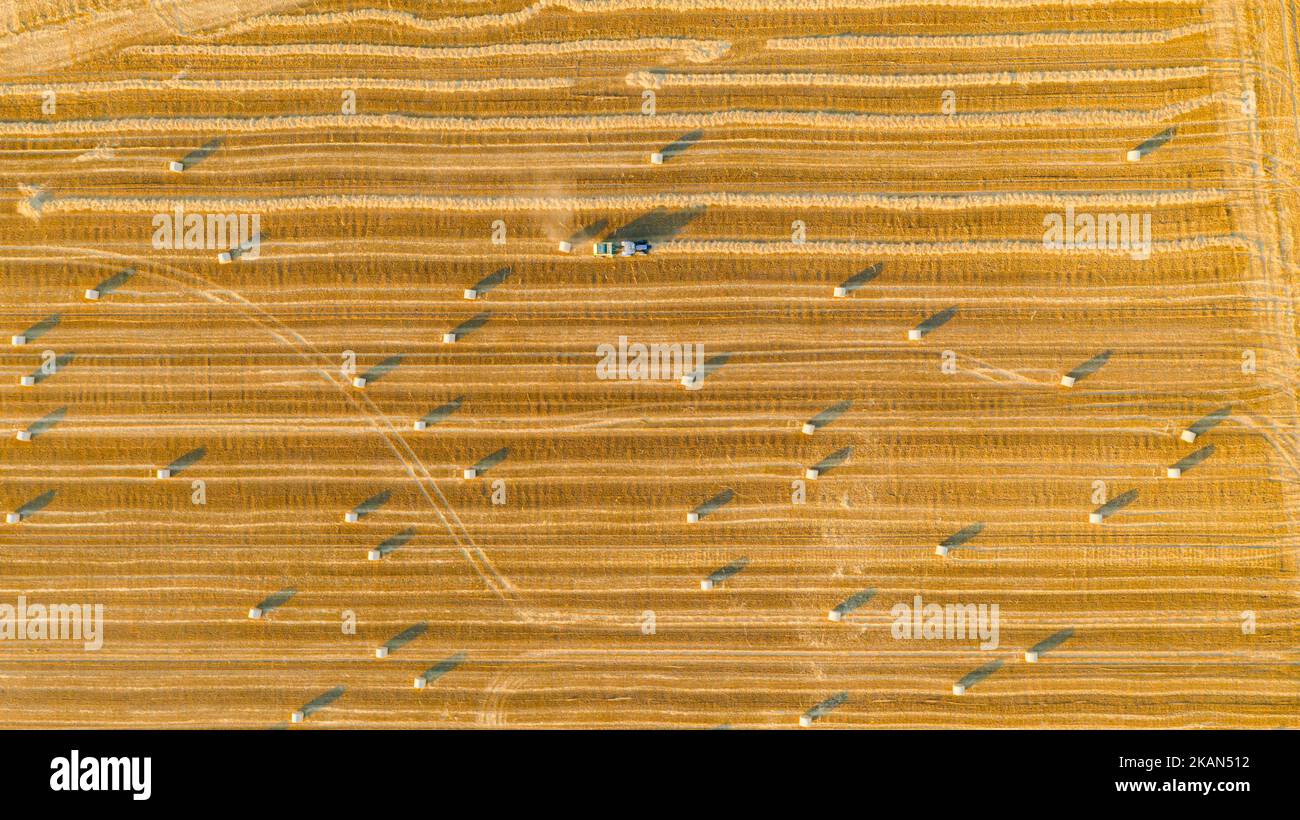 Above top view on tractor as pulling round baler, machine that rolls up ...