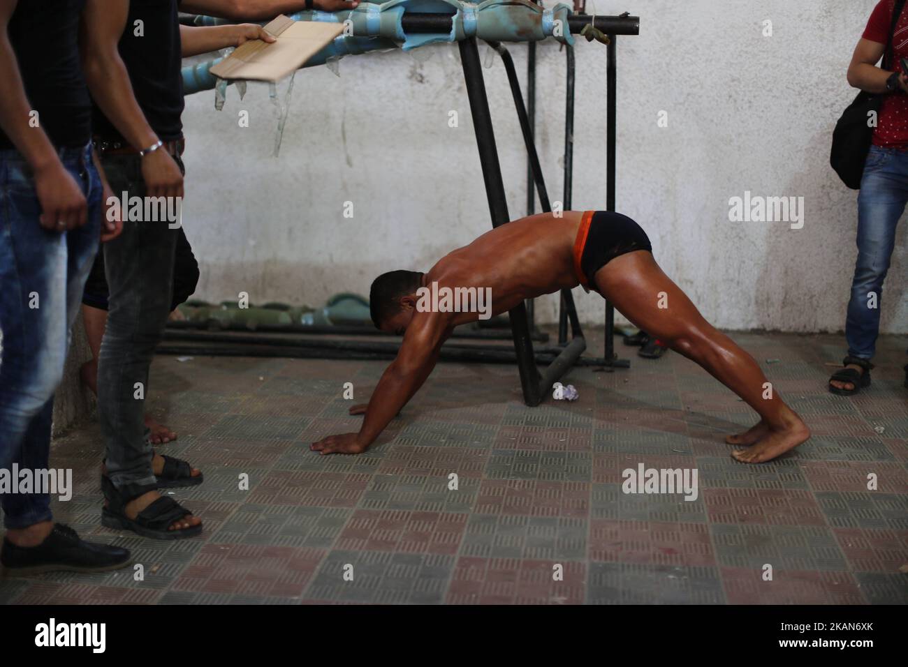 Palestinian men flex their muscles as they compete during a Gaza Strip ...