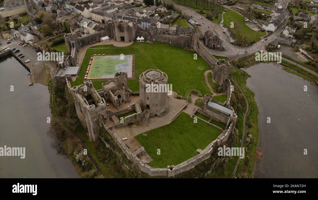 A high angle of the Pembroke castle on a green hill top surrounded by ...