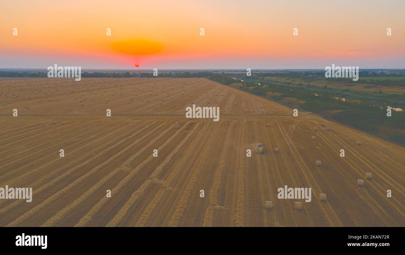 Above view on tractor as pulling round baler, machine that rolls up the ...