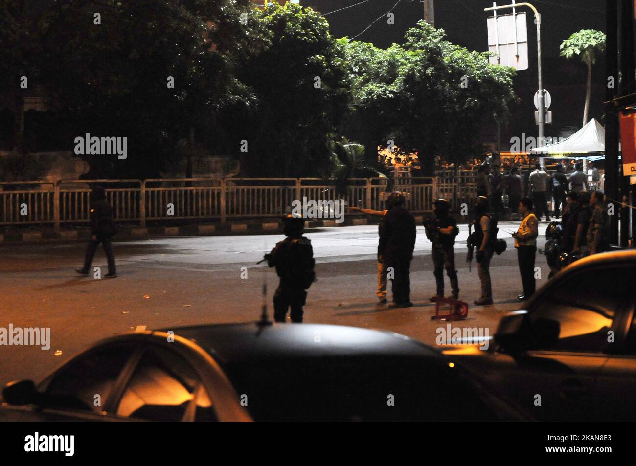Police bomb squad members inspect the site of an explosion in Jakarta ...
