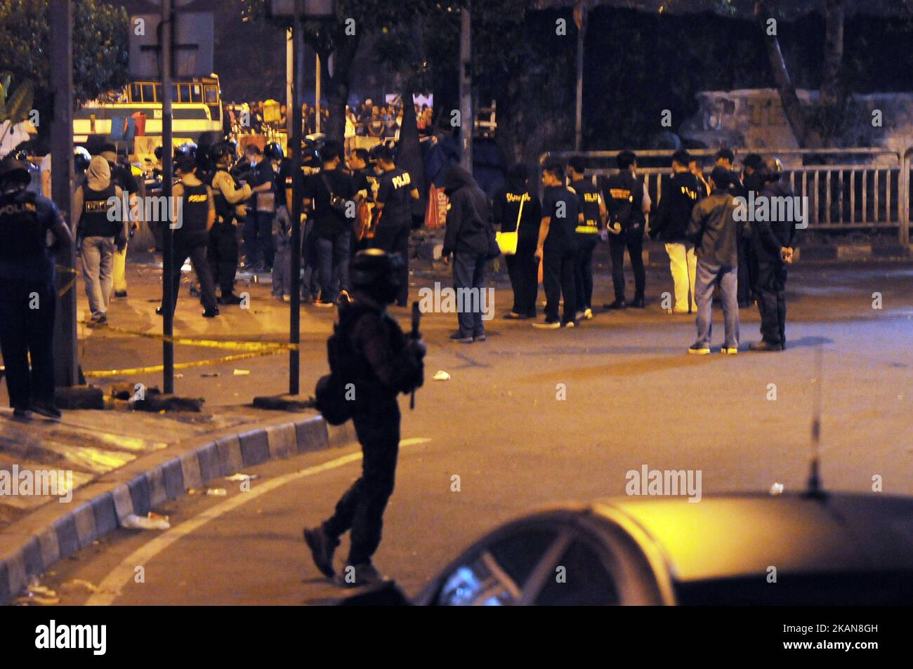 Police bomb squad members inspect the site of an explosion in Jakarta ...