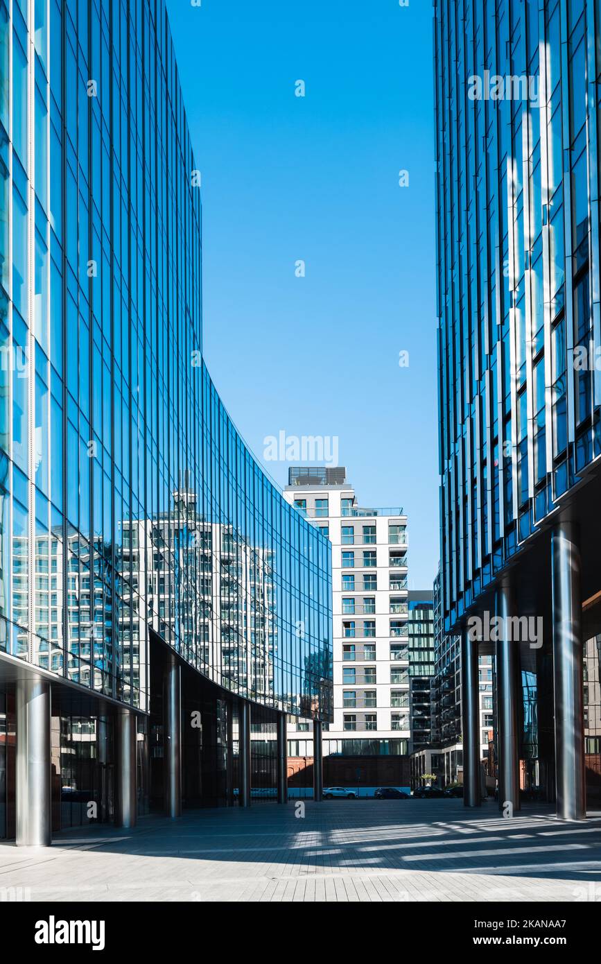Walkway between modern glass buildings with metal columns Stock Photo ...