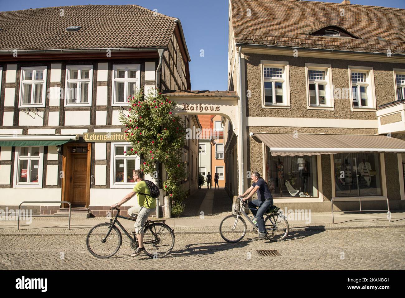 People ride by bike in a street in the city center of Luebbenau in the region of the Spreewald ...