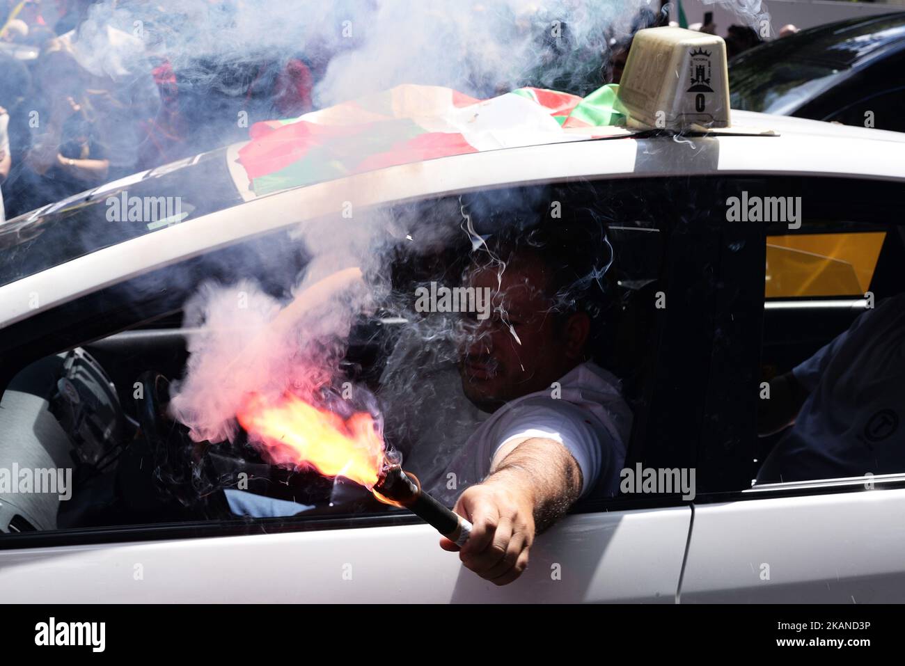 People holding smoke bombs march during a protest by a Spanish taxi ...