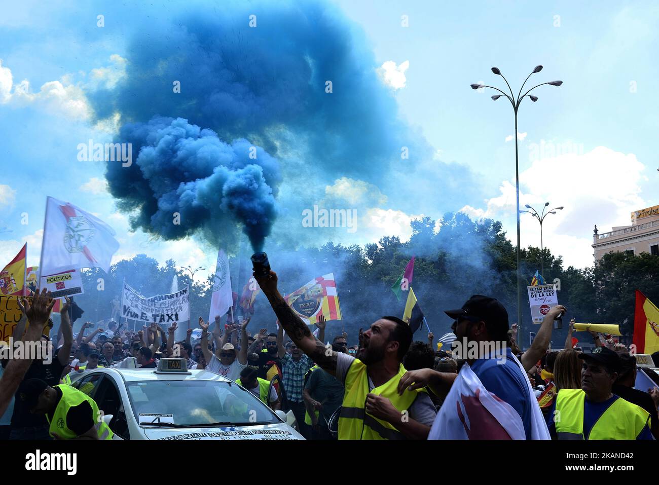 People holding smoke bombs march during a protest by a Spanish taxi ...