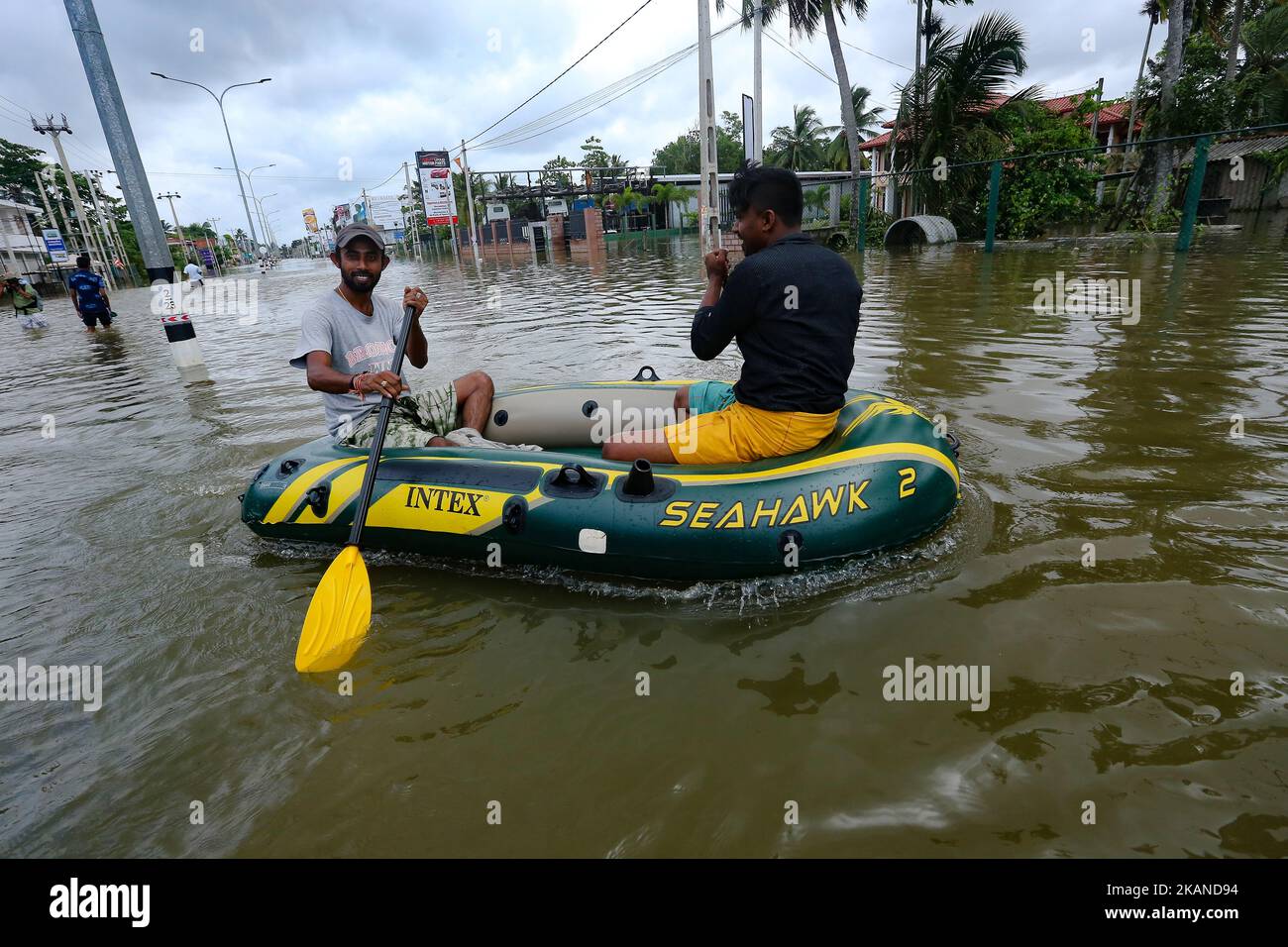 Sri Lankan men use a boat as a mode of transportation to travel across ...