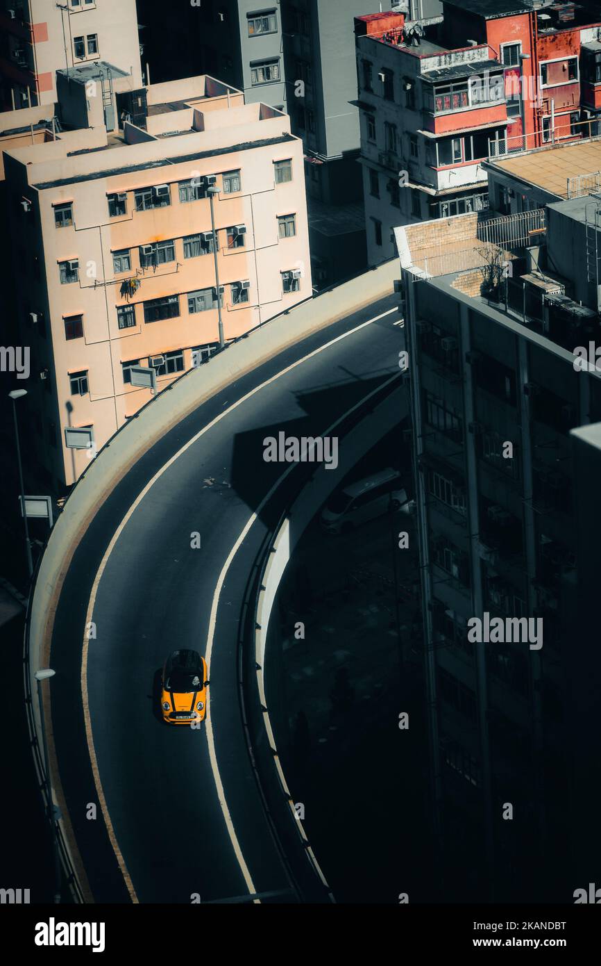 The yellow Mini Cooper turning in the road with the urban cityscape ...