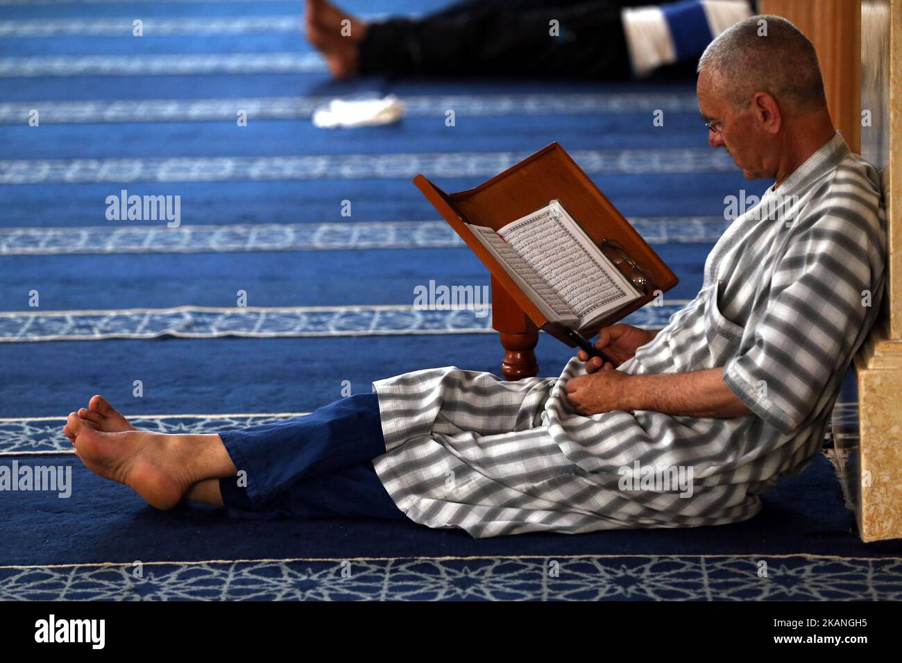 An Algerian Muslim reads the Koran in a mosque in Boufarik, Algeria, on ...