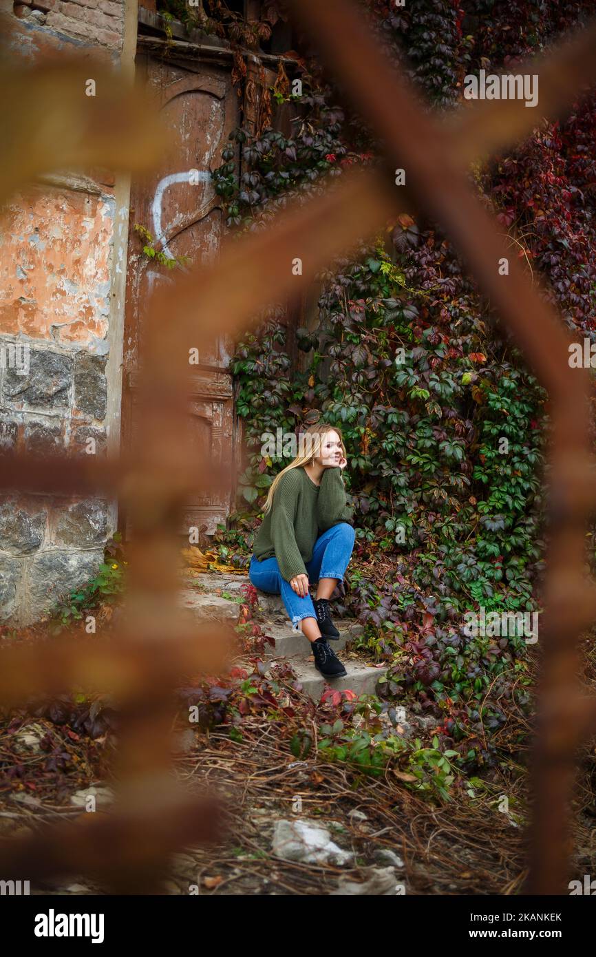 Walk of a beautiful girl in a sweater and jeans Stock Photo - Alamy