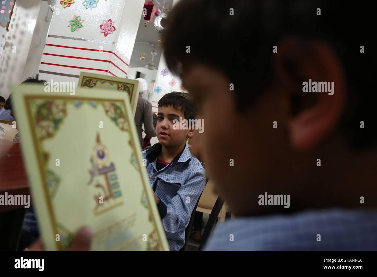 Syrian boys read the Koran as part of a charity program for orphans in ...