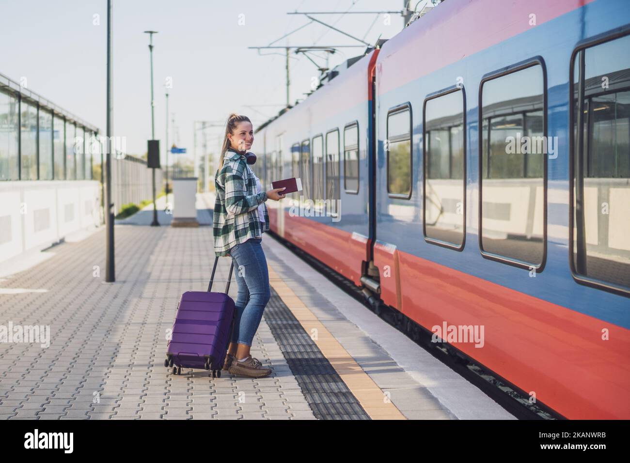 Woman with suitcase holding ticket and waiting to enter into the train ...