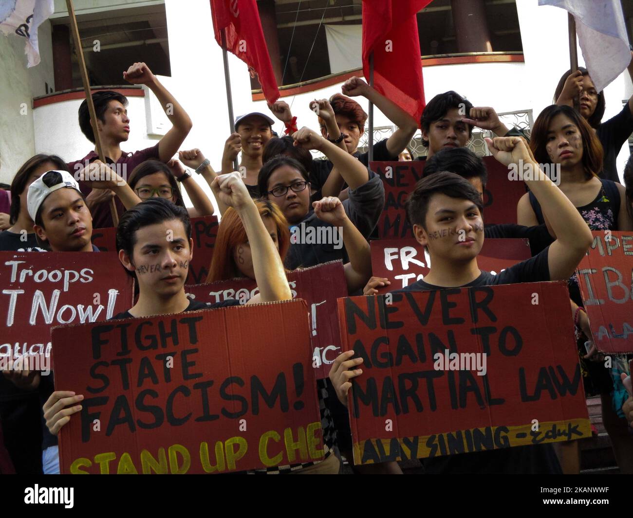 Student activists holding slogans raise clenched fists during a rally ...